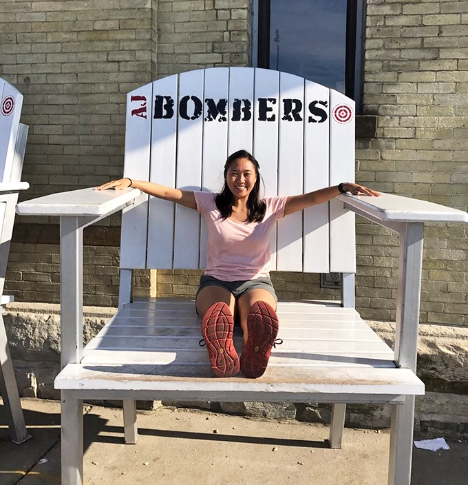 The oversized Adirondack chair outside isn't just photo-op furniture—it's a metaphor for how AJ Bombers makes everything feel larger than life.