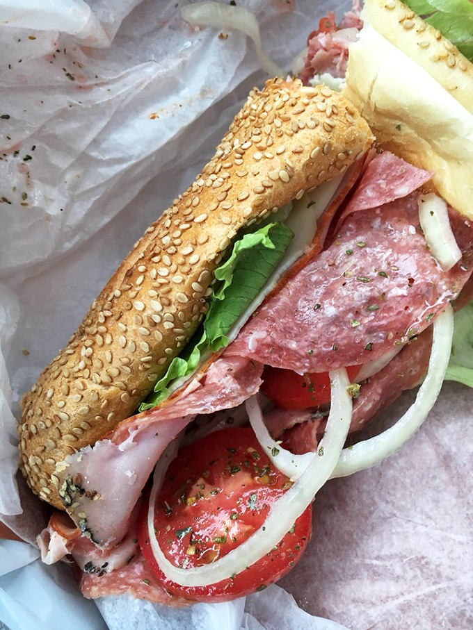 Italian cold cuts layered with precision on a sesame-studded roll – this isn't just lunch, it's a Mediterranean vacation between two pieces of bread.
