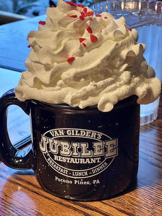 Hot chocolate that's wearing a party hat! This towering whipped cream masterpiece isn't a beverage—it's a celebration in a mug.