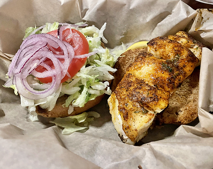 A sandwich that requires both hands and your full attention. That perfectly seasoned fish deserves nothing less than complete devotion with every bite.