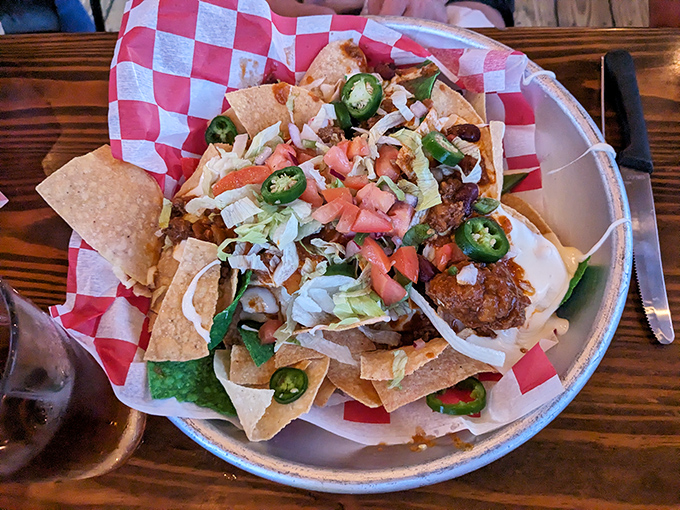 These nachos aren't just a starter—they're an event. Jalapeños stand at attention among a mountain of toppings that demand to be shared.