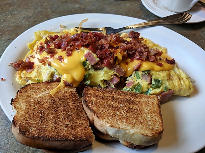 This isn't just an omelet – it's a masterpiece of morning engineering. Cheese cascades over perfectly cooked eggs while bacon adds the exclamation point.