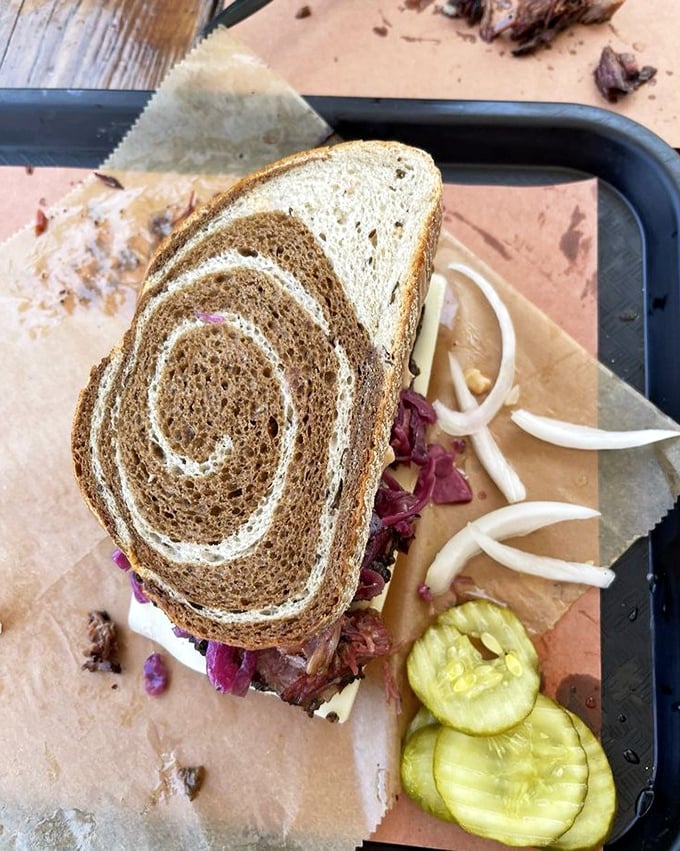 A sandwich that requires both hands and a strategy—marble rye spirals holding a mountain of meat that's worth every napkin you'll need.