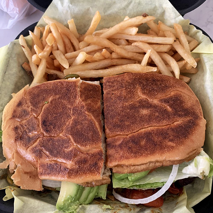 This torta isn't just a sandwich—it's architecture. Perfectly toasted bread creating a foundation for layers of flavor, with fries standing by for backup.