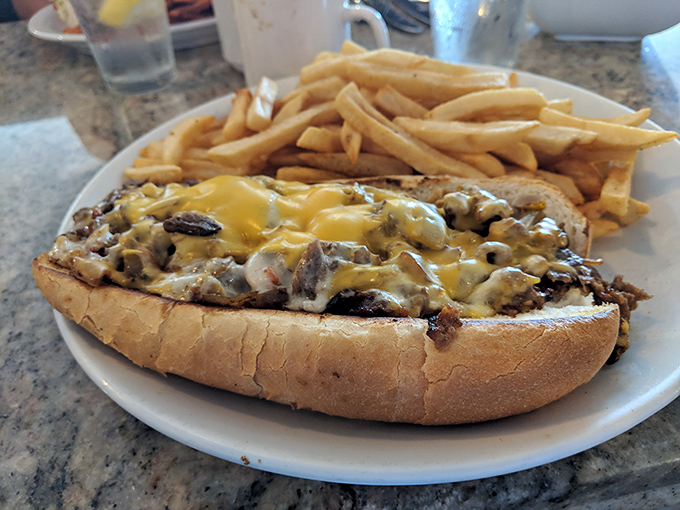 This cheesesteak sandwich isn't just lunch—it's an edible hug. Those fries are standing by, ready for their supporting role.