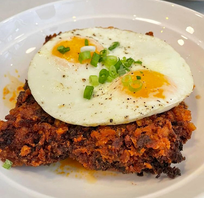 Breakfast reimagined: a crispy hash foundation crowned with sunny eggs that stare back at you like delicious golden eyes.