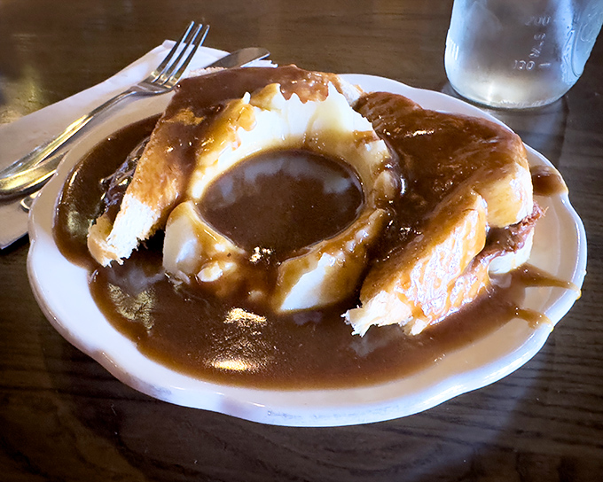 Hot roast beef sandwich swimming in gravy—where the bread isn't just a delivery system, it's a willing participant in delicious excess.