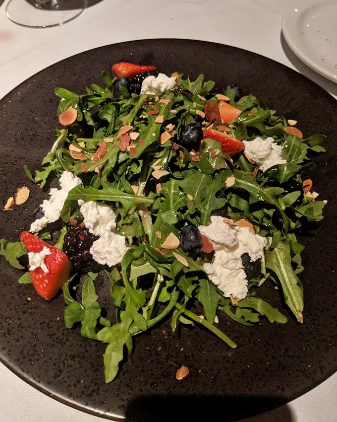 A salad that doesn't apologize for being healthy—it's too busy showing off its arugula, berries, and cheese in a delicious balancing act.
