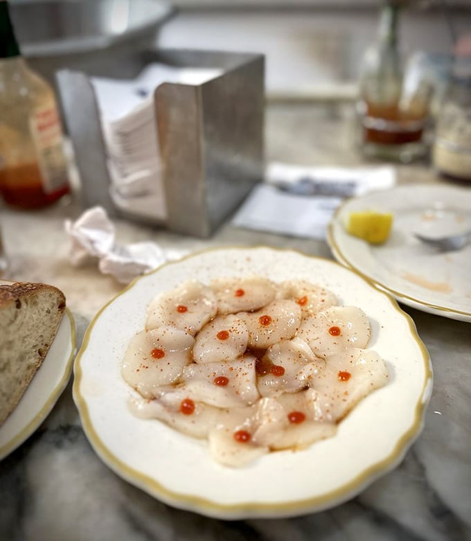 Scallop sashimi dotted with tiny pearls of roe – delicate, sweet morsels that taste like the ocean's most elegant whisper.