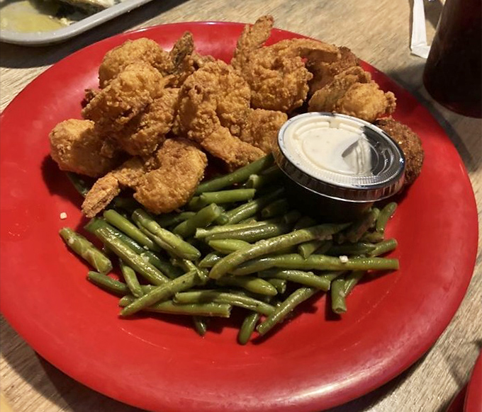 Golden-fried shrimp arranged like delicious soldiers alongside vibrant green beans. A simple, satisfying plate that delivers exactly what it promises.