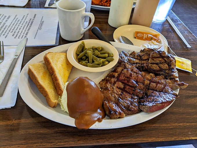 This steak didn't just meet the grill—they had a passionate affair. The toast and green beans are just trying not to feel awkward about it.