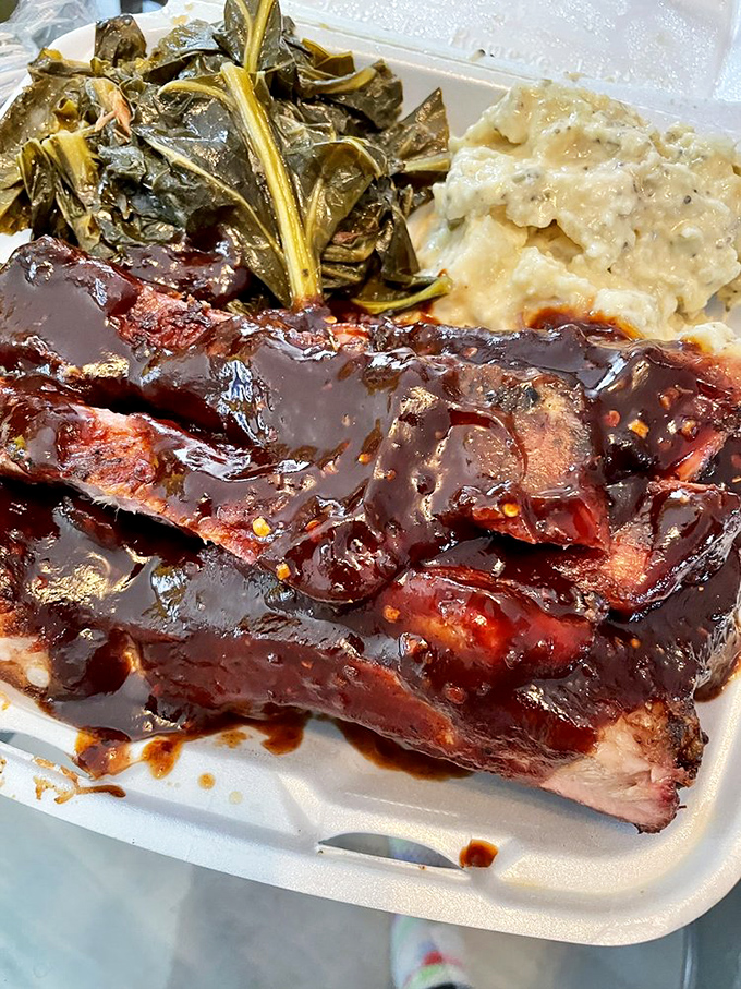 Saucy ribs nestled beside collard greens and potato salad—a trifecta of Southern comfort that makes you want to hug your plate.