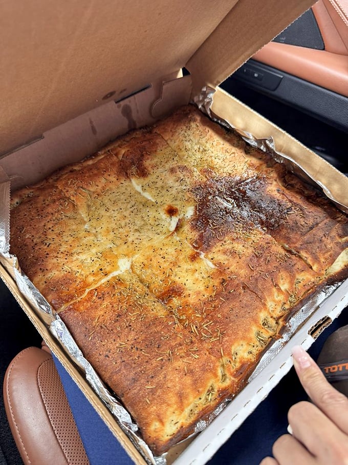 The white pizza in its to-go box—herb-flecked, golden-crusted perfection that makes car rides home an exercise in tremendous willpower.