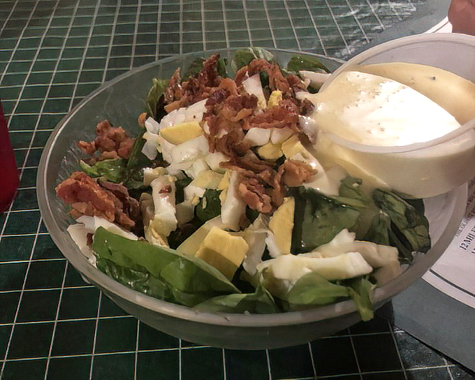 A salad that doesn't apologize for the bacon bits. When greens come topped with eggs and bacon, even vegetable-avoiders get curious.