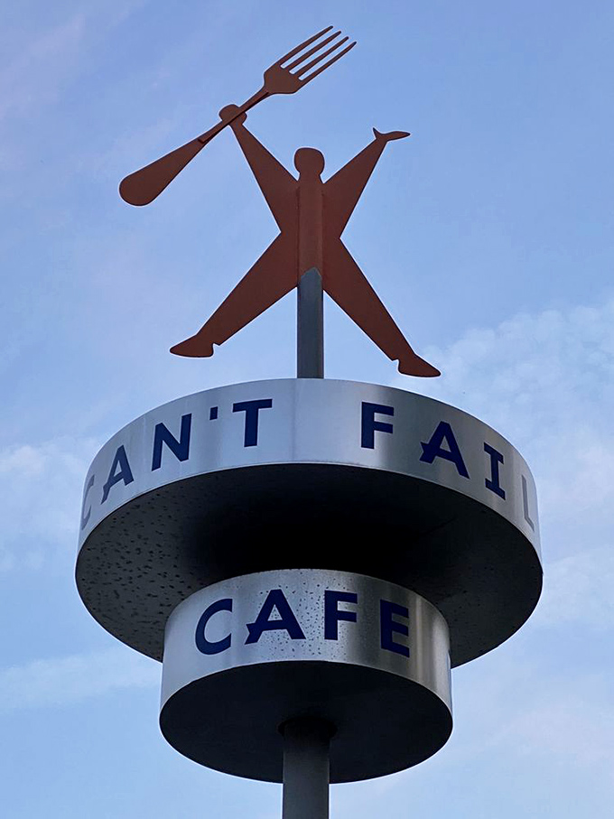 The restaurant's iconic mascot—fork in hand, ready to eat—stands tall above the Rudy's sign, a beacon for hungry travelers.