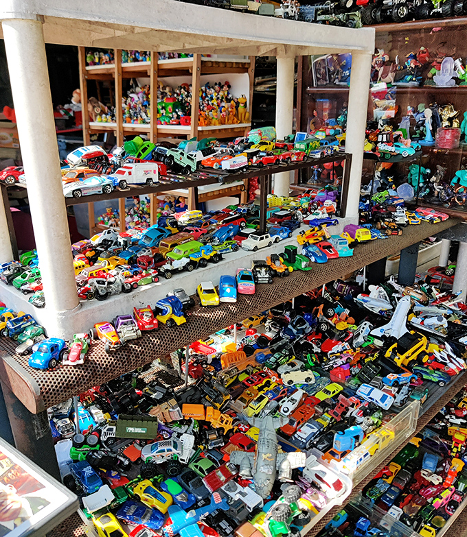 Toy cars in magnificent chaos—a miniature traffic jam spanning decades of automotive history. Every boy's dream collection, no assembly required.