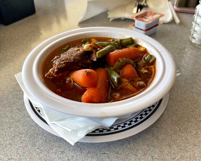 A bowl of vegetable beef soup that could solve most of life's problems. Tender chunks of beef, garden-fresh vegetables, and a broth worth sipping directly from the bowl.