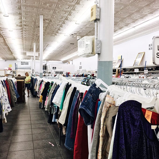 Fashion history lessons hanging on metal racks under vintage tin ceilings. Each garment represents both someone's past and someone else's future find.