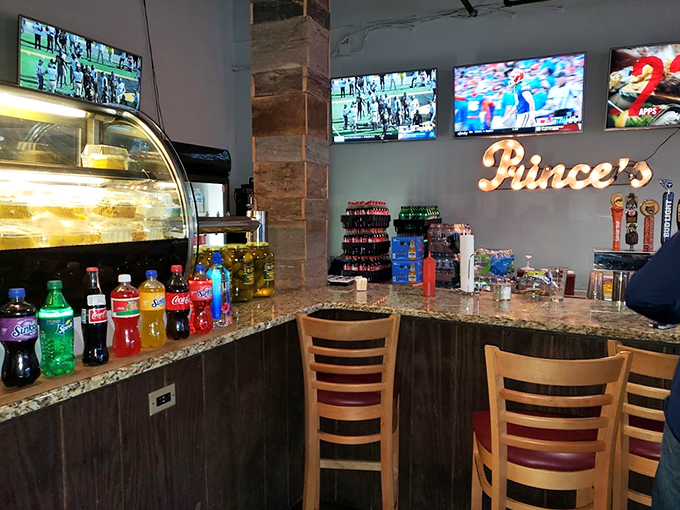 The bar area: where cold beverages stand ready to extinguish the flames. Those TVs aren't for entertainment—they're to distract you from the heat.