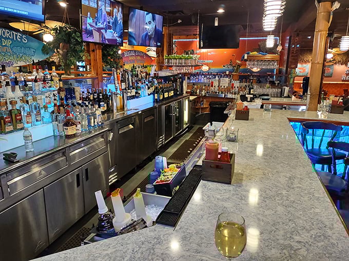 The bar area—where seafood stories grow taller with each round, and strangers become friends united by their mutual appreciation for perfectly mixed coastal cocktails.