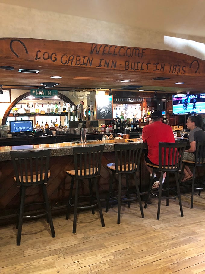 The bar at Log Cabin Inn isn't just serving drinks—it's preserving history. That wooden beam proudly announcing "Built in 1885" has stories to tell.