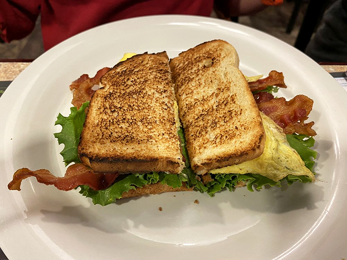 This sandwich isn't just stacked—it's architecturally sound. Crispy bacon and fresh lettuce create the perfect textural contrast between perfectly toasted bread.