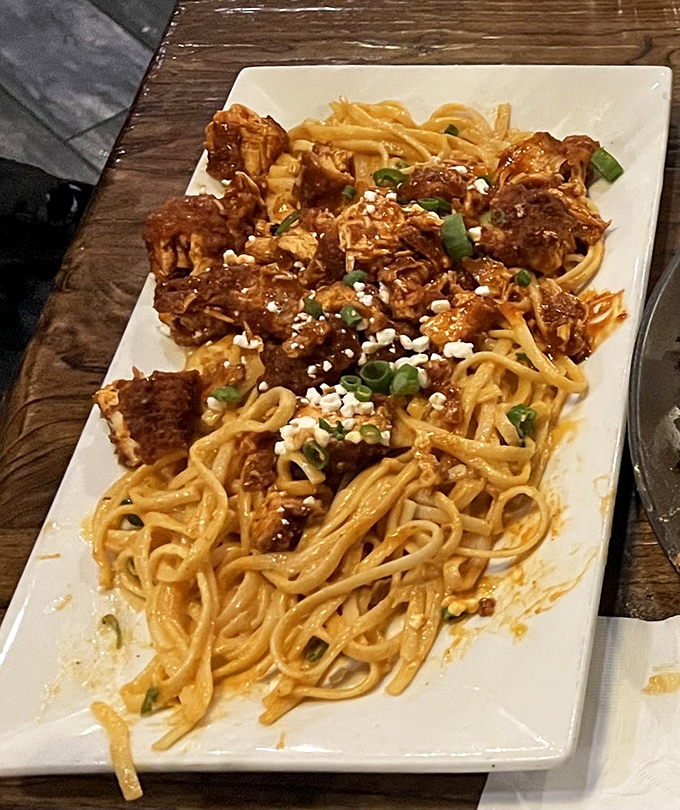 Pasta that doesn't need to be in Italy to be authentic – creamy, topped with green onions and what appears to be tender chunks of meat.