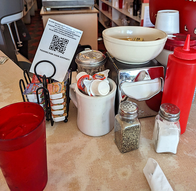 The condiment caddy—civilization's greatest achievement. Salt, pepper, sugar, and ketchup: the four elements of diner alchemy.
