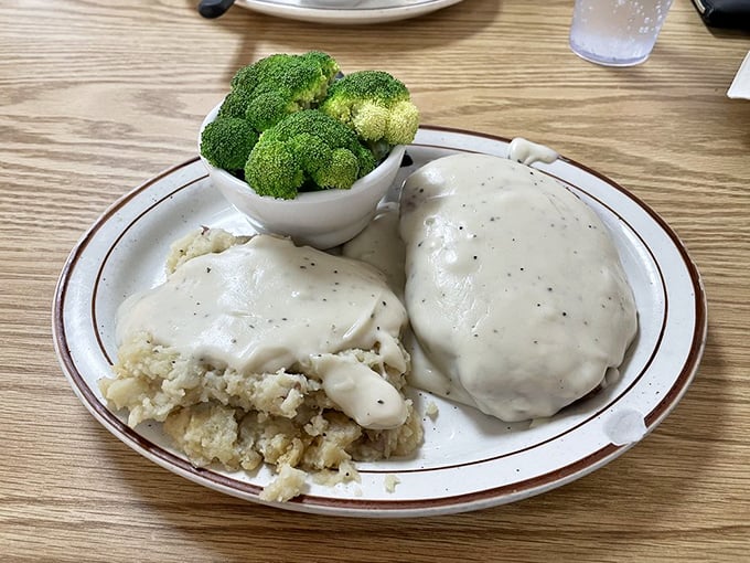 Country-fried comfort on a plate—tender meat beneath creamy gravy alongside mashed potatoes that clearly never came from a box.