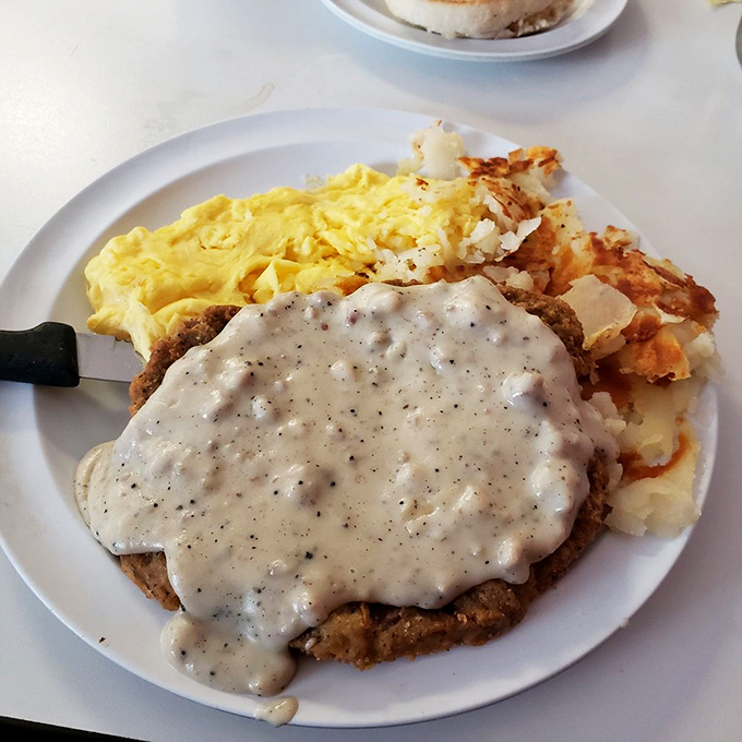 Country fried steak swimming in peppery gravy – comfort food that wraps around your soul like your grandmother's warmest hug.