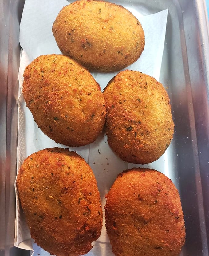 These golden-fried deviled crabs aren't just appetizers; they're crispy orbs of seasoned perfection that make you question why you'd ever start a meal any other way.