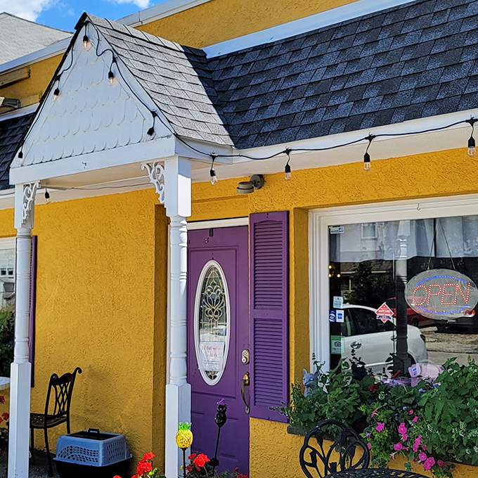 That purple door isn't just an entrance – it's a portal to comfort food paradise, framed by cheerful flowers and charming architectural details.