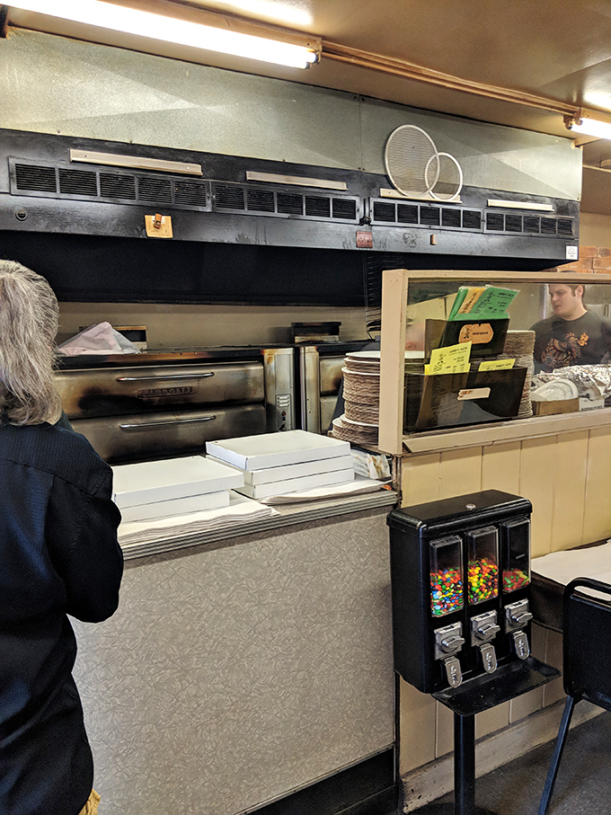 A glimpse into the kitchen reveals the heart of the operation. Those pizza boxes await their precious cargo like blank canvases.