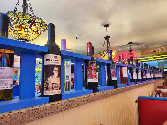 Wine bottles line blue shelves like sentinels guarding the secret to a good meal—proof that this diner understands food is meant to be celebrated.