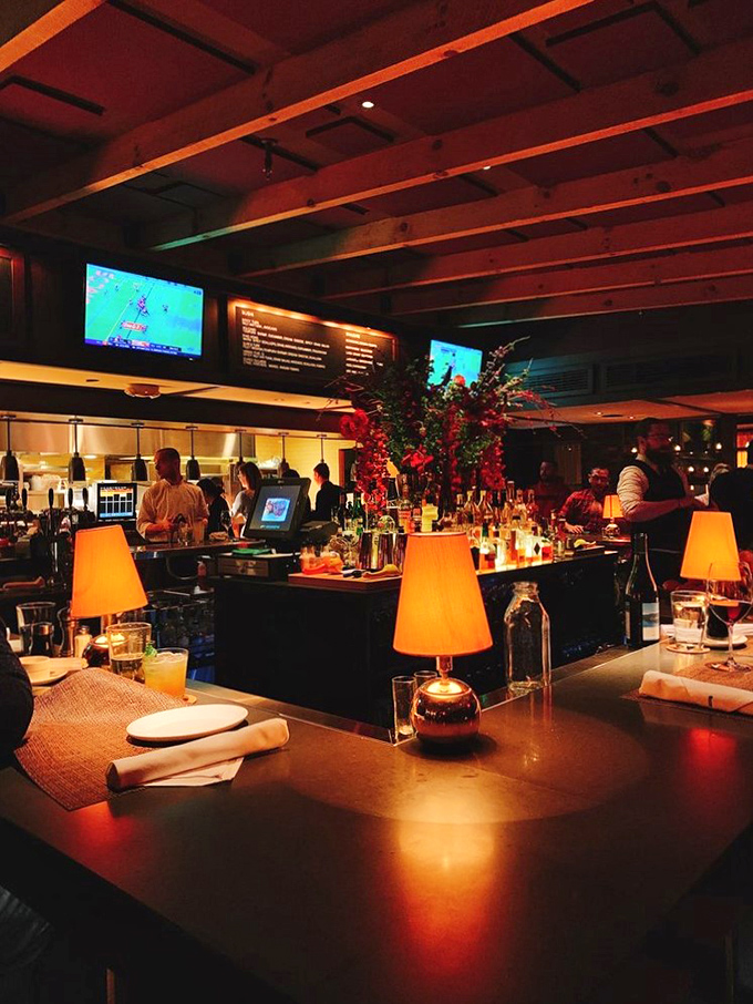 Evening transforms the bar into a warm sanctuary of amber light and conversation—where strangers become friends over perfectly mixed cocktails.