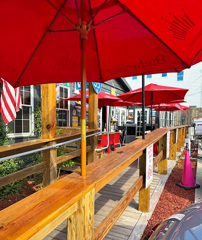 The wooden deck and red umbrellas create the perfect casual vibe. It's like your coolest friend built a porch and invited everyone over.
