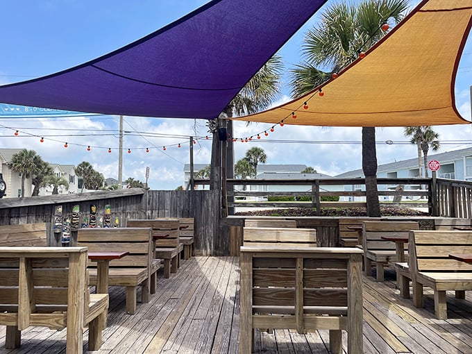 The outdoor deck, shaded by colorful sails, where the sea breeze serves as nature's air conditioning and salt perfumes every bite.