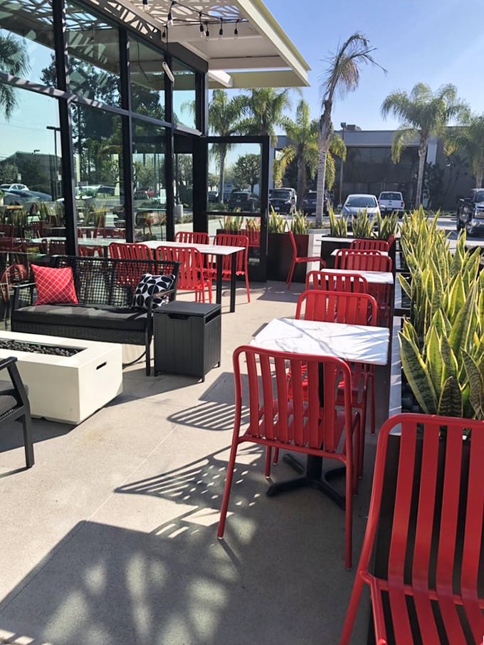 The outdoor patio with its bright red chairs invites you to enjoy your slice under California sunshine—pizza weather is always perfect weather.