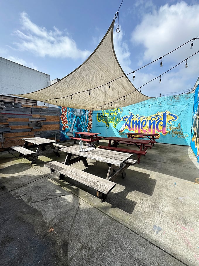 The patio at Spinning Dough offers urban sanctuary vibes with picnic tables, string lights, and colorful murals—a perfect California pizza paradise.