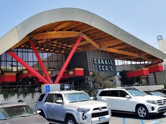 The distinctive curved roof and bold red supports make Connie and Ted's impossible to miss—architectural shorthand for "seriously good seafood happens here."