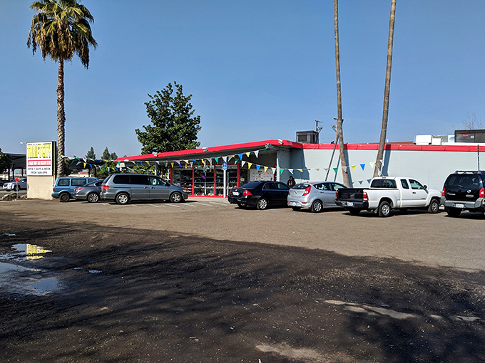 California thrifting at its finest—where palm trees stand guard over a parking lot full of cars containing soon-to-be-thrilled bargain hunters.
