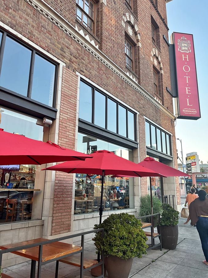Red umbrellas beckon sidewalk strollers: "Yes, you could keep walking, or you could have one of the best burgers in Los Angeles."