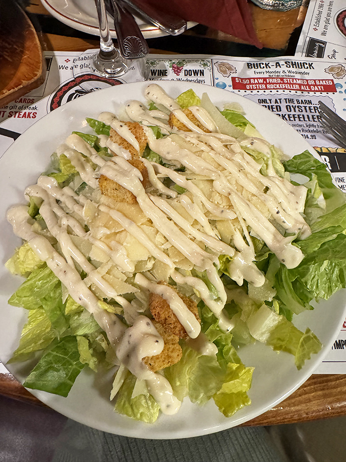 Caesar salad dressed to impress—crisp romaine wearing creamy dressing like it's heading to a formal dinner party.