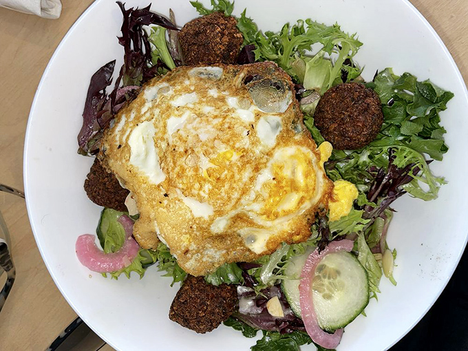 A salad that doesn't apologize for being healthy—that perfectly cooked egg on top is the breakfast equivalent of a cherry on a sundae.