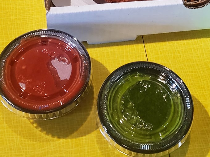The sauces – one classic red, one herbal green – are the unsung heroes of any great pizza experience, ready to elevate your crust-dipping game.