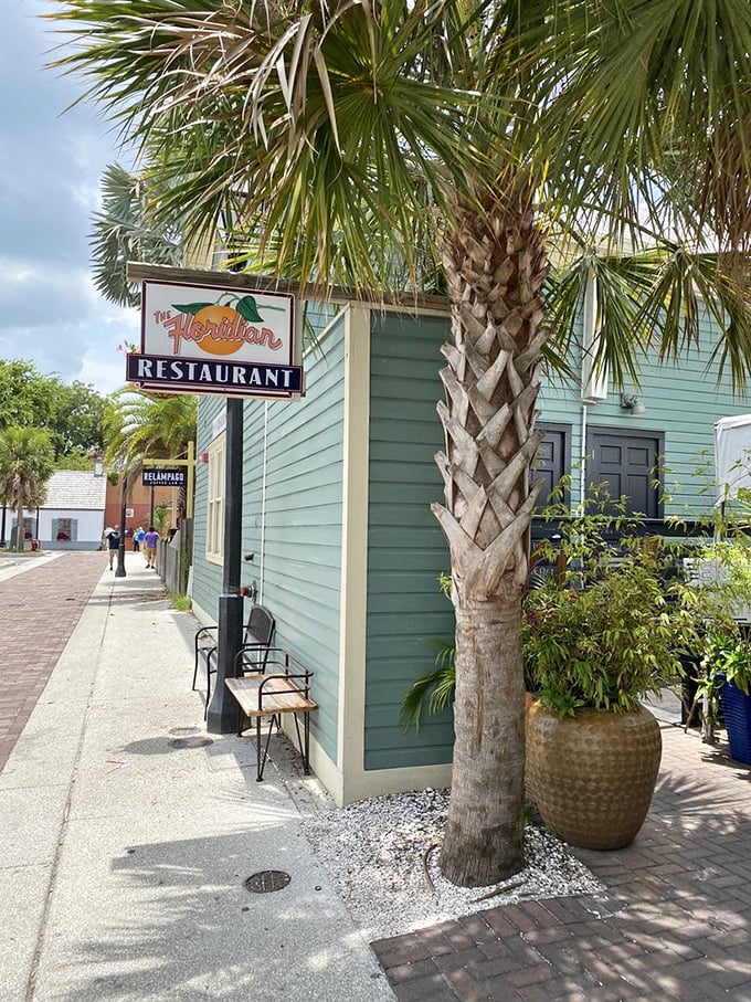 The restaurant's sign sways gently beneath palm fronds—a perfect marriage of Old Florida charm and contemporary culinary promise.