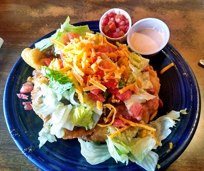 Fresh, colorful, and piled high with goodness – this isn't just lunch, it's edible artwork on blue ceramics.