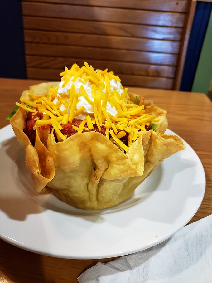 Taco salad served in a freshly fried tortilla bowl—a crunchy, edible vessel holding a fiesta of flavors topped with a snow-capped mountain of sour cream.