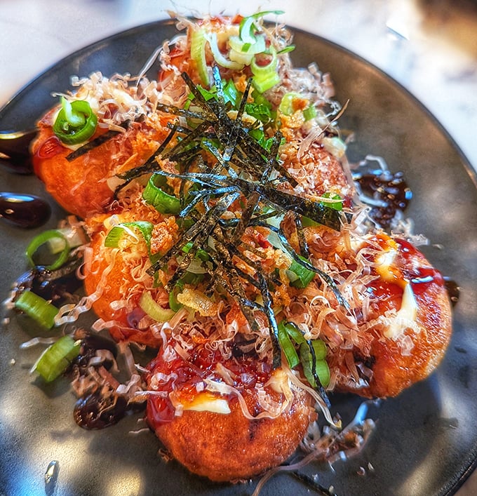Takoyaki balls topped with dancing bonito flakes – like tiny octopus-filled planets orbiting your plate.