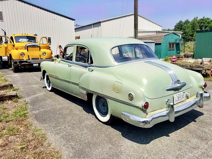A mint-green vintage automobile from the era when cars began replacing trolleys sits on display. The irony isn't lost – this beauty represents what ultimately dethroned the trolley kings.